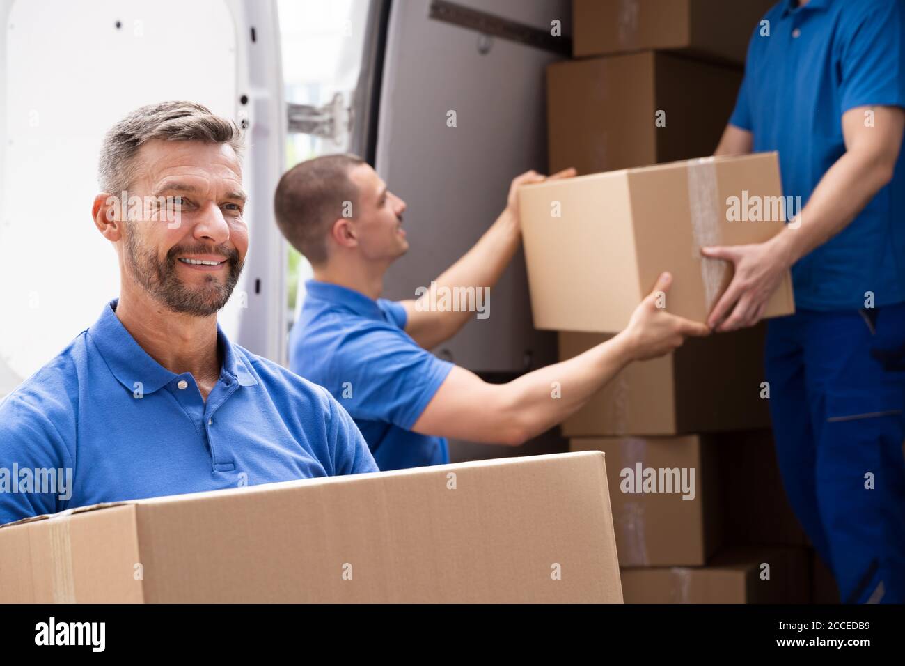 Delivery man carrying boxes on a hand truck hi-res stock photography ...