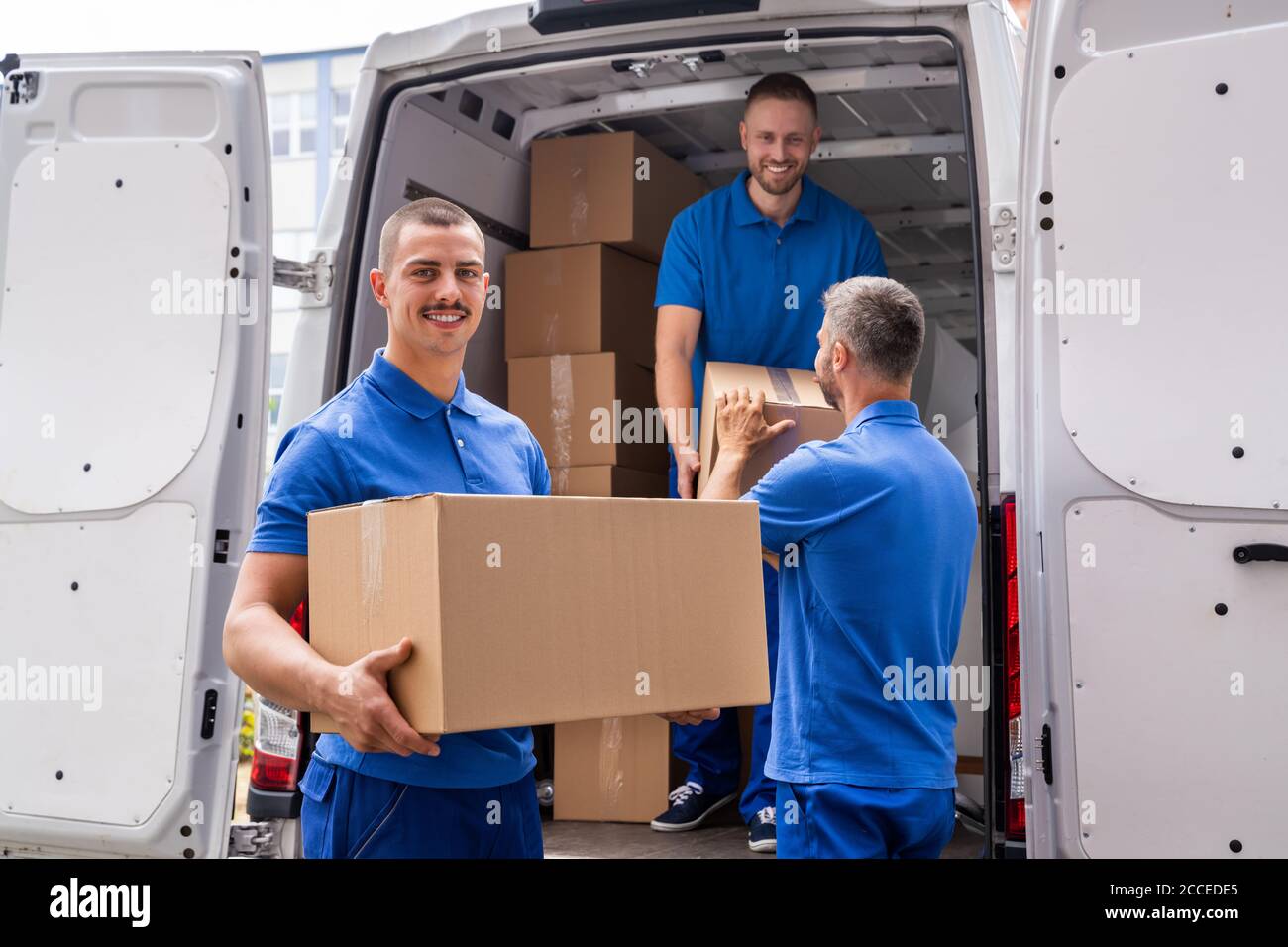 Delivery man carrying boxes on a hand truck hi-res stock photography ...