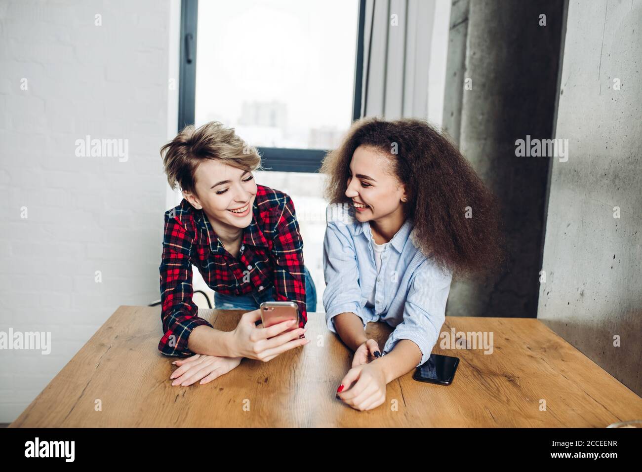 two positive girls are discussing messages with each other. friendship ...