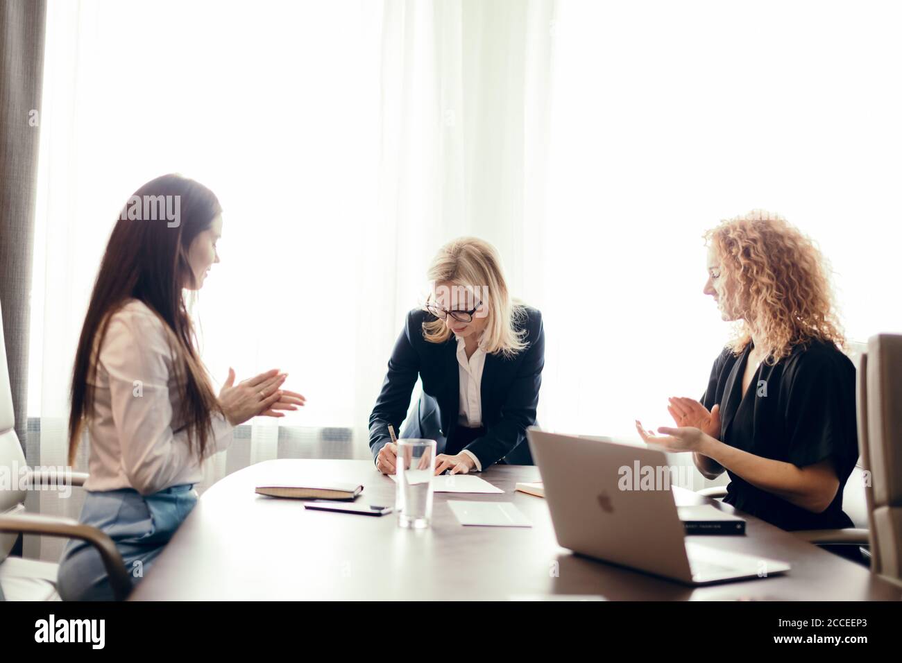 women s business concept. Young blonde female official signs papers to ...