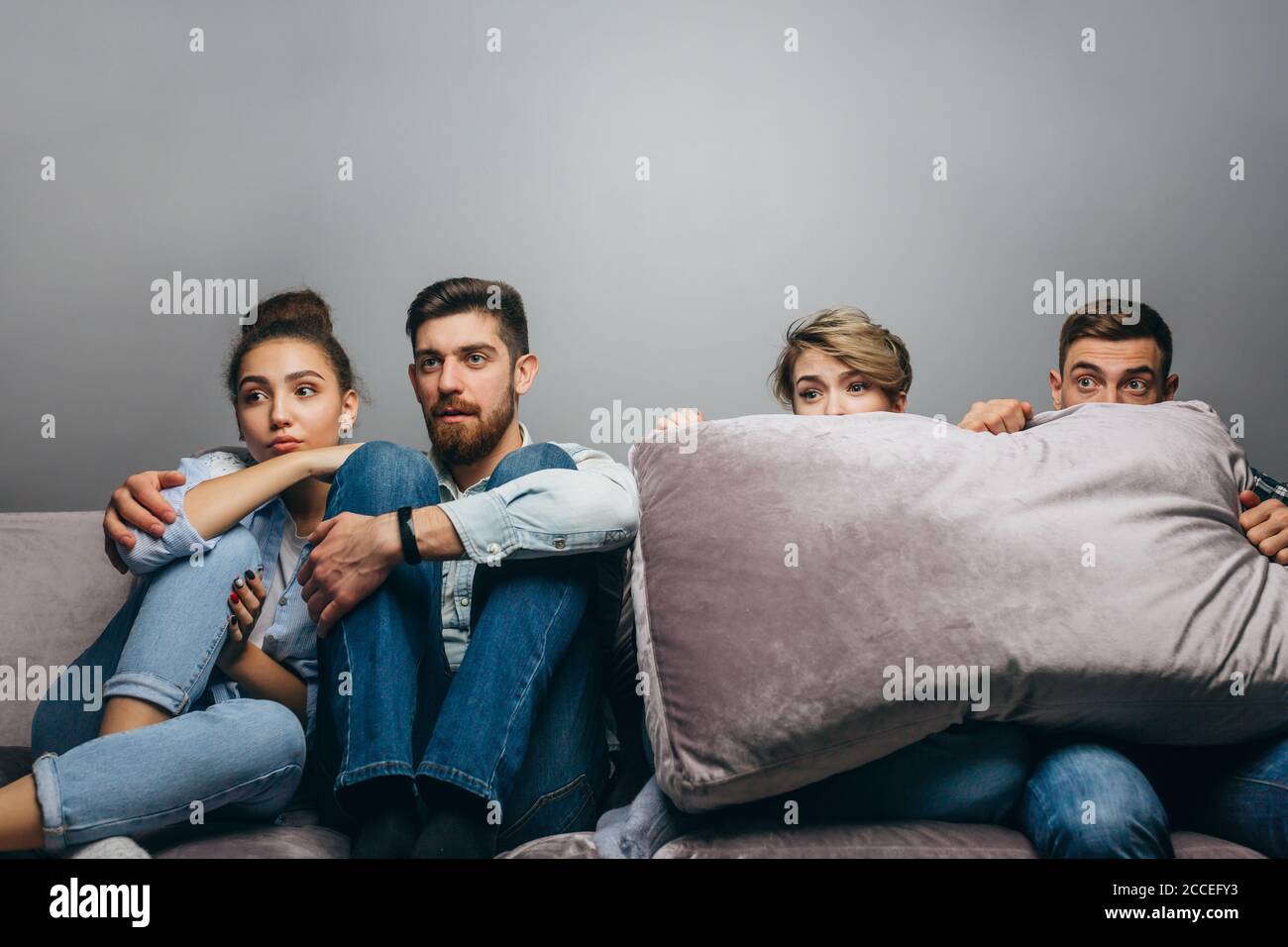 scared young people are watching horror movie. close up shot. free time ...