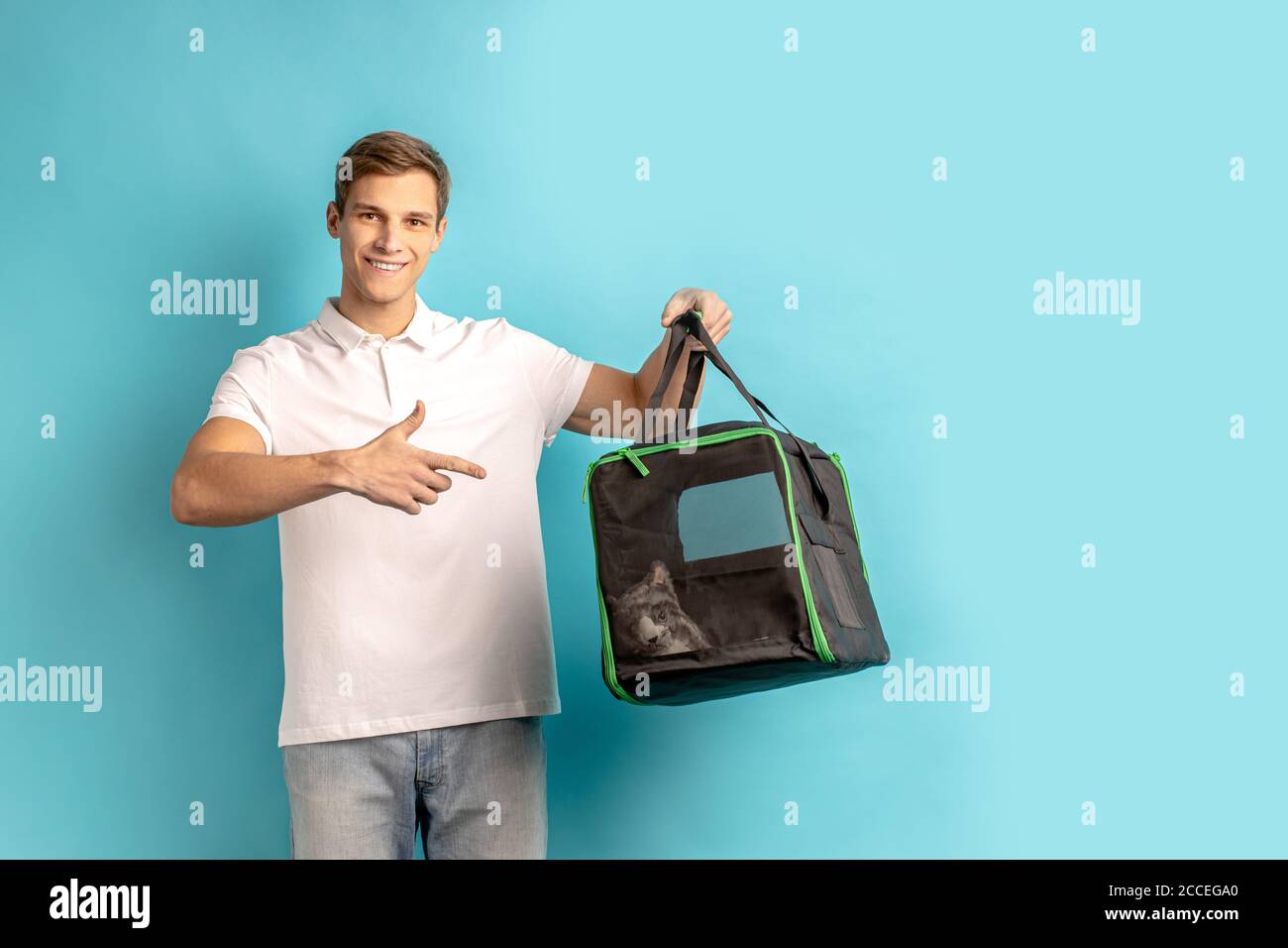 portrait of young caucasian delivery man holding bag with animal ...
