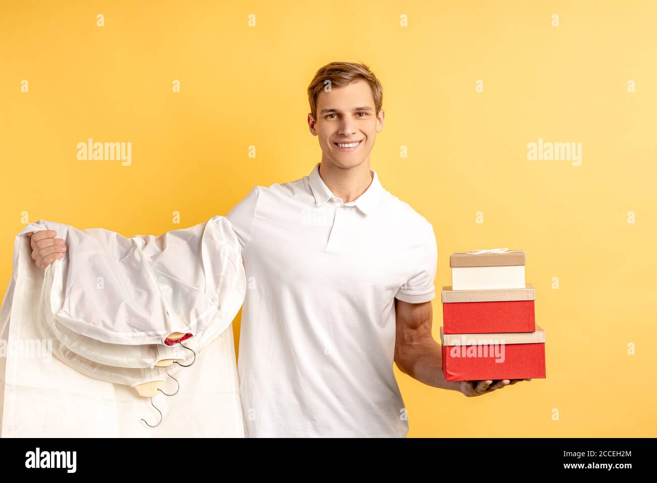 good-looking caucasian young delivery man in white unifrom holding red ...