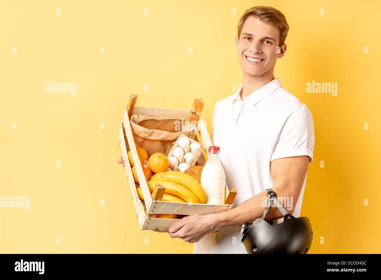 portrait of confident young delivery man carrying fresh food ...