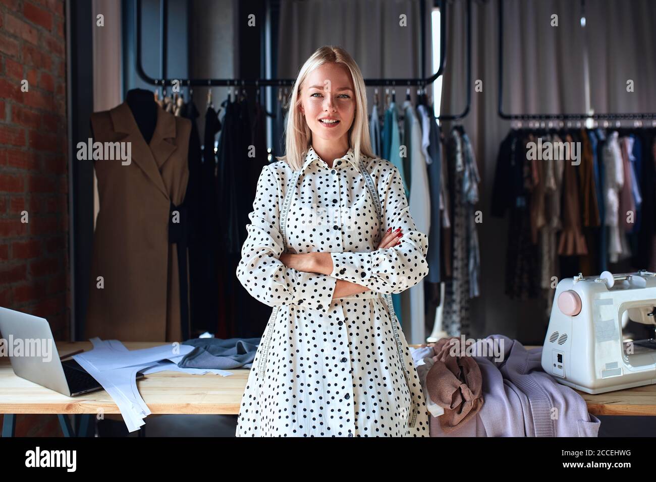 Young attractive fashion designer stand at workplace, look at camera ...