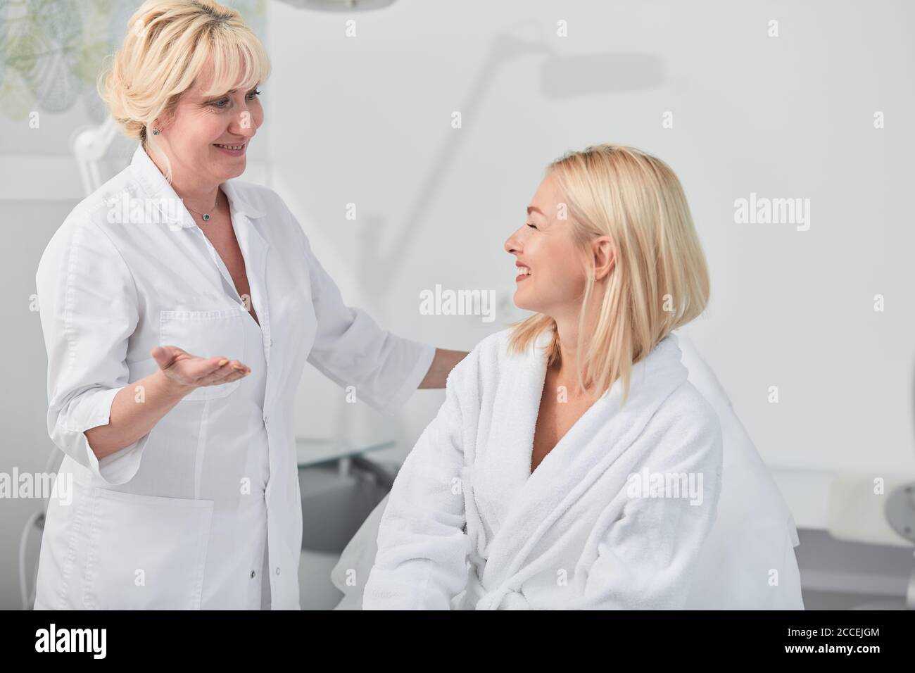 cosmetologist and client having fun in the clinic, close up photo ...