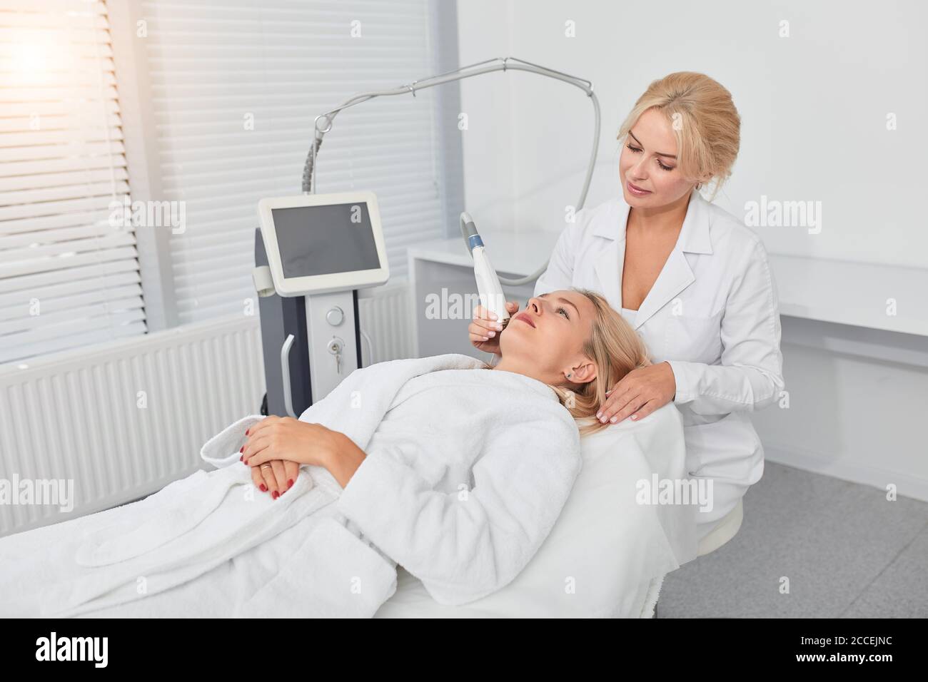 relaxed blonde client treating her unhealthy face at modern clinic ...