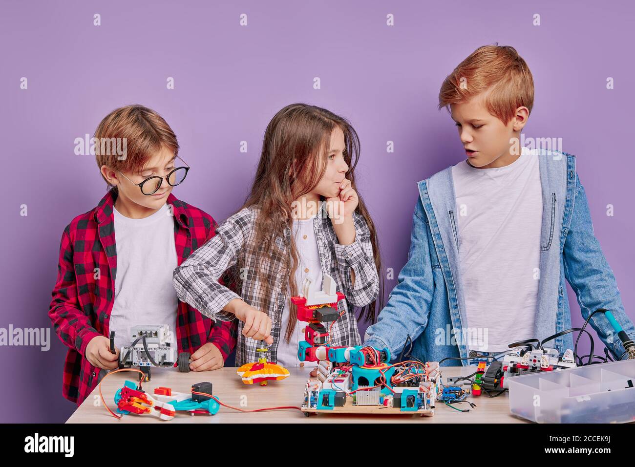 Portrait of caucasian little children assembling robots - group of ...