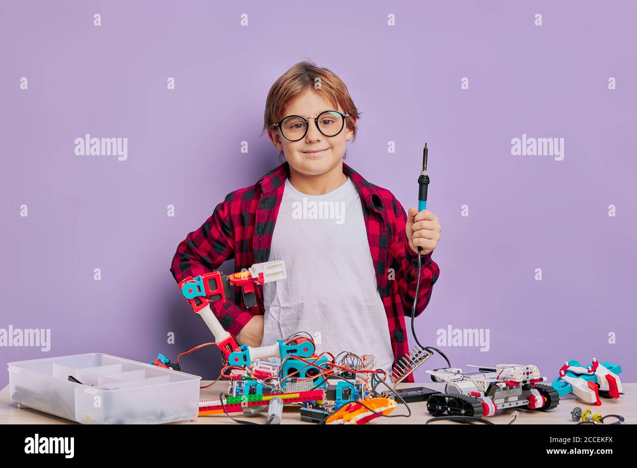 little caucasian kid boy interested in assembling different robots in ...