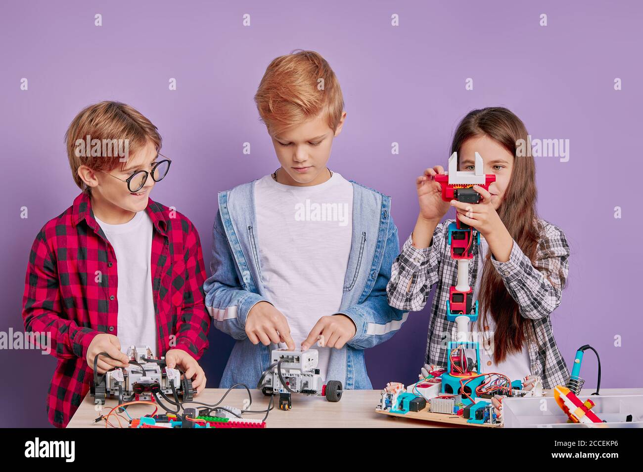 Portrait of caucasian little children assembling robots - group of ...