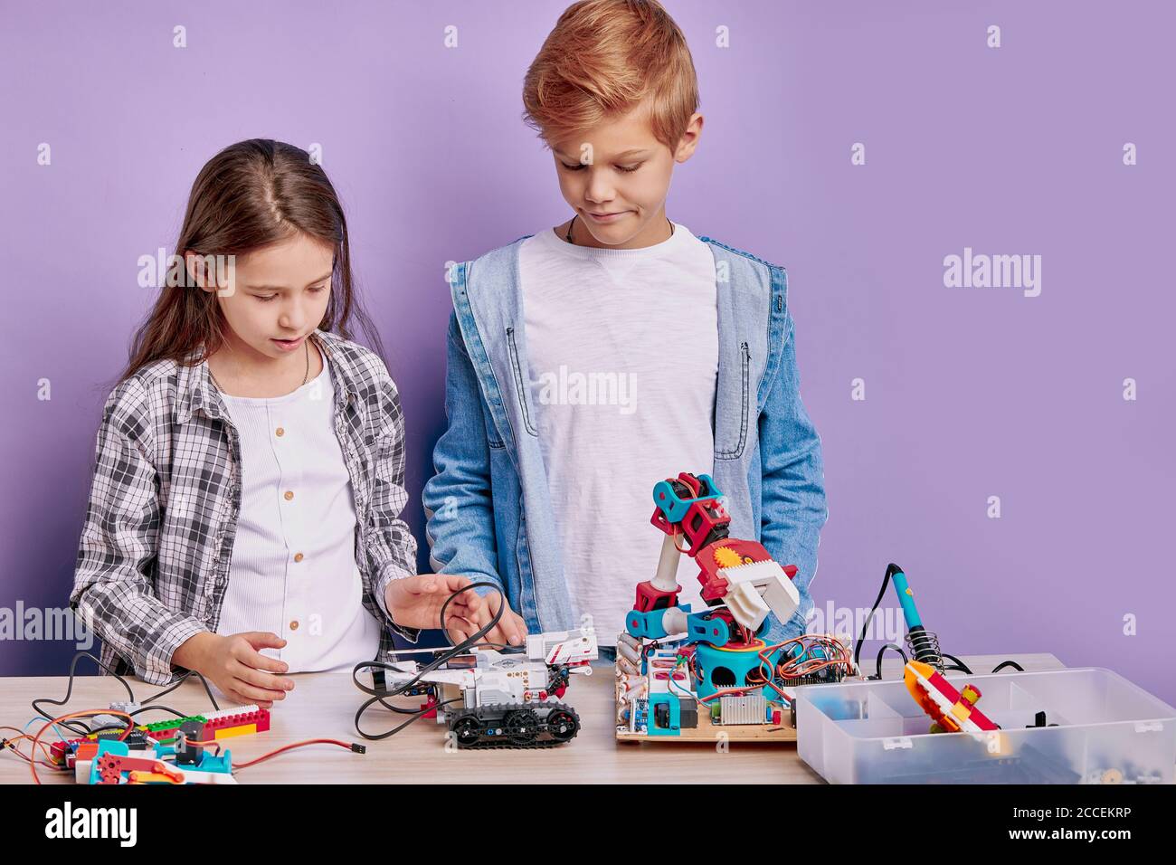 portrait of smart children aiming to make a robot isolated in studio ...