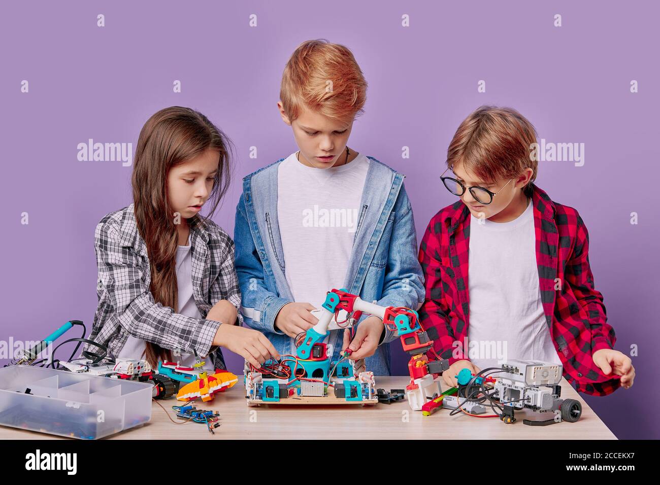 Portrait of caucasian little children assembling robots - group of ...