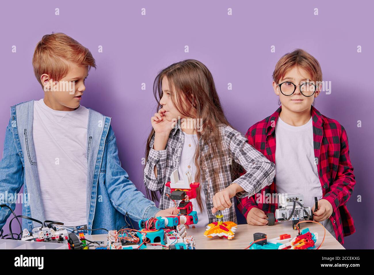 thoughtful children practive engineering first time, look at each other ...
