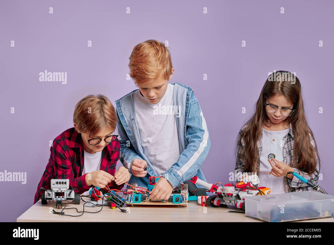 portrait of little 6-8 years old children stand together near table and ...
