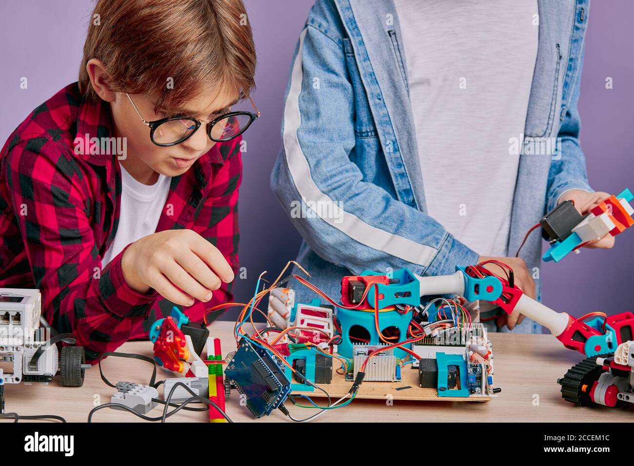 robotics activity of three caucasian children assembling toys, future ...