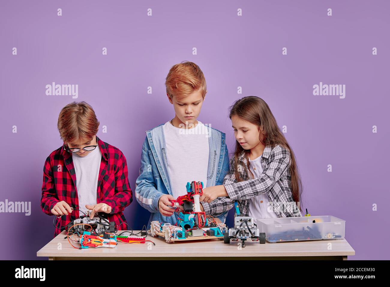 Portrait of caucasian little children assembling robots - group of ...