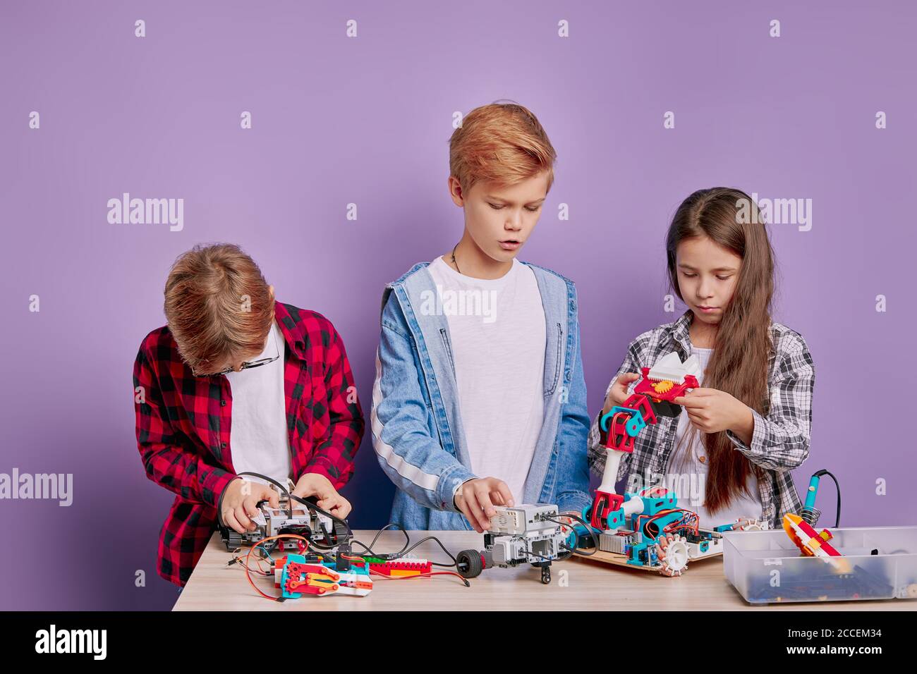 Portrait of caucasian little children assembling robots - group of ...