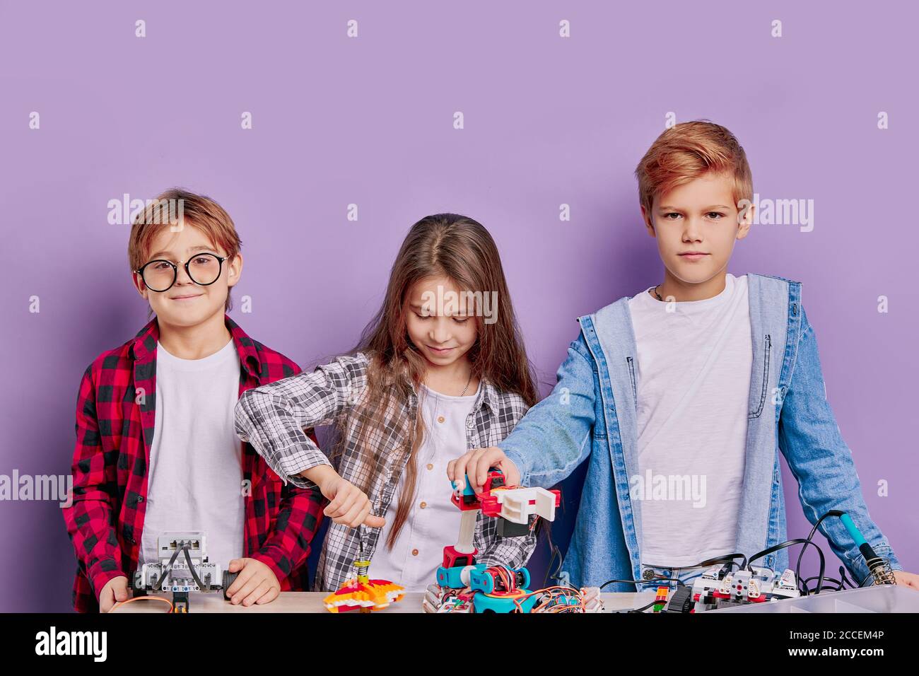 caucasian little children assembling robots - group of happy kids or ...