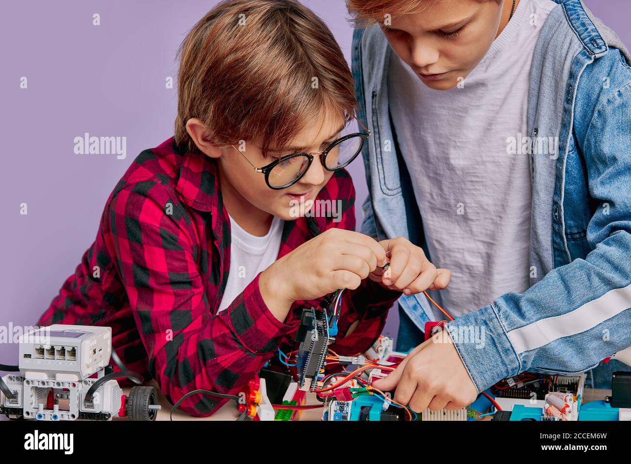 close-up portrait of boys diligently assembling robots, careful kids ...