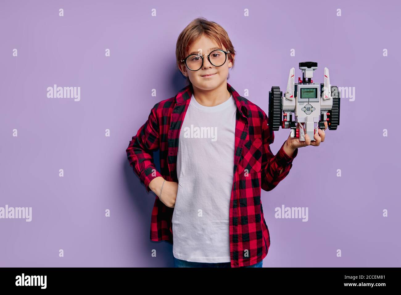 clever smart kid boy in red shirt interested in engineering, robotics ...