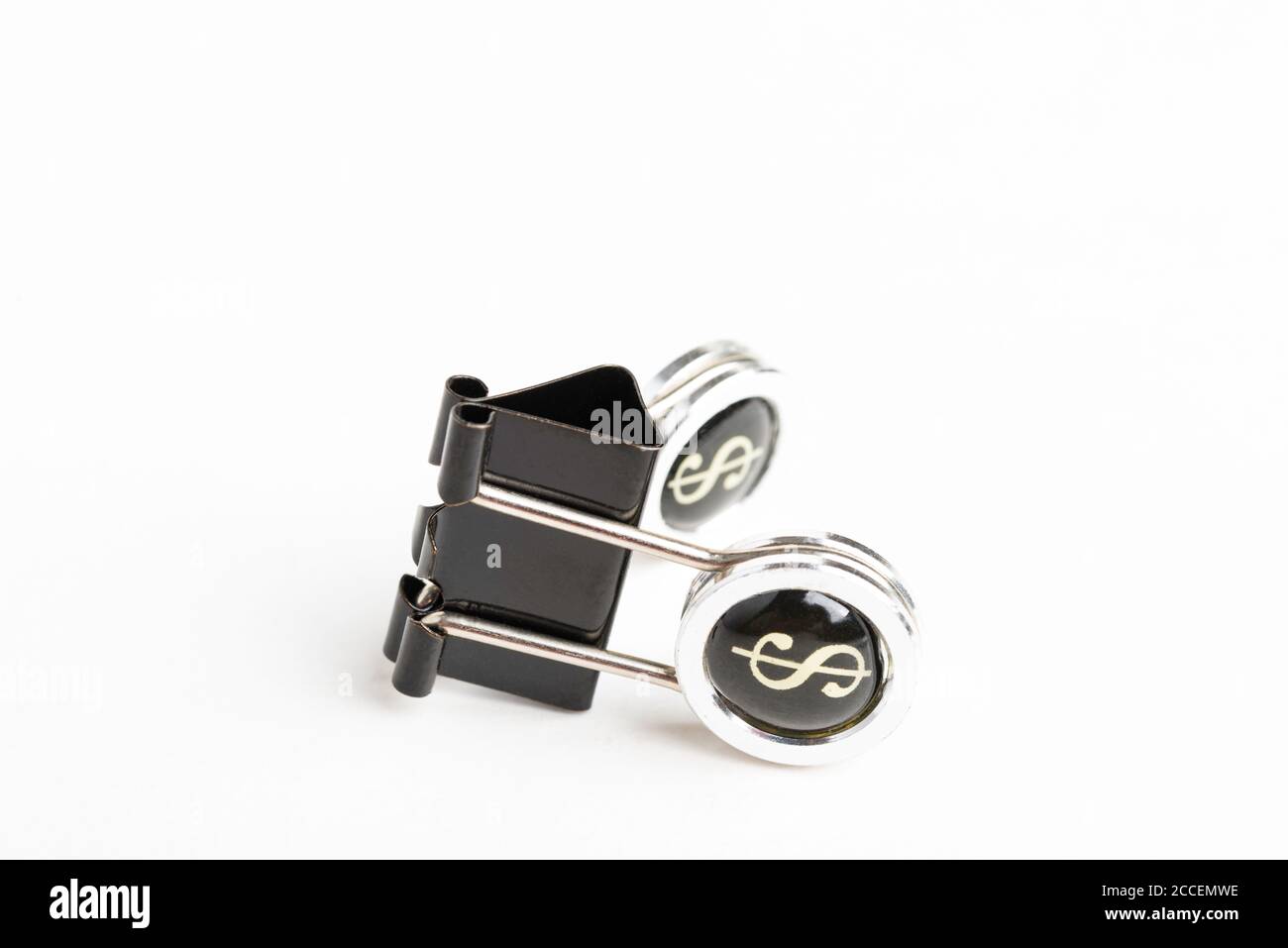 A close-up of a black document clip with a circular press handle ...