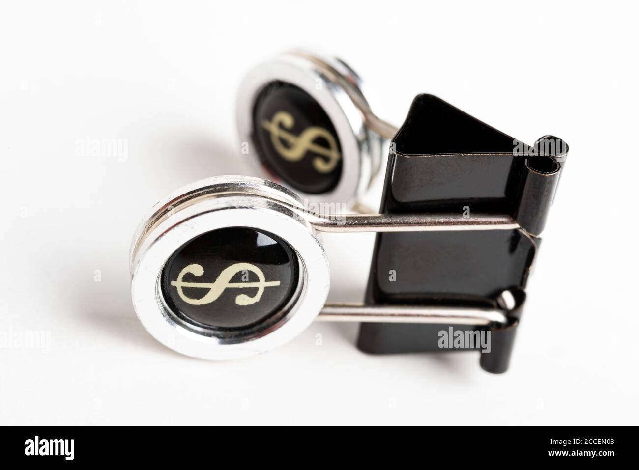 A close-up of a black document clip with a circular press handle ...