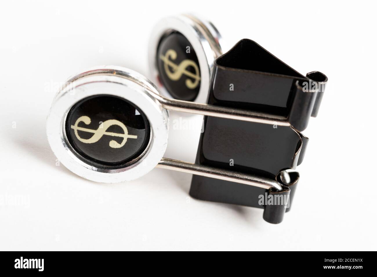 A close-up of a black document clip with a circular press handle ...