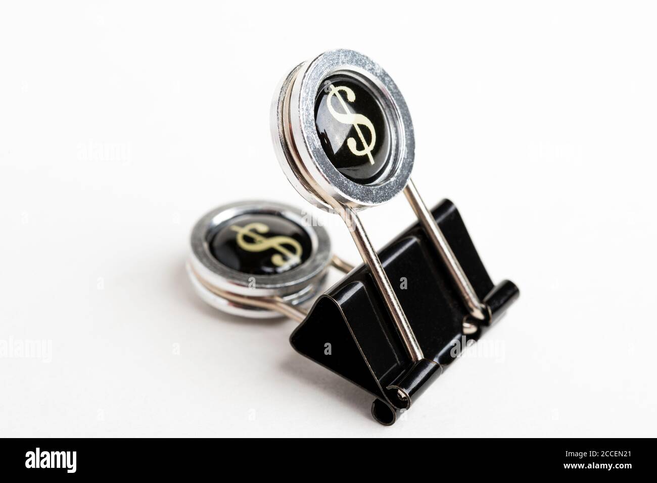 A close-up of a black document clip with a circular press handle ...