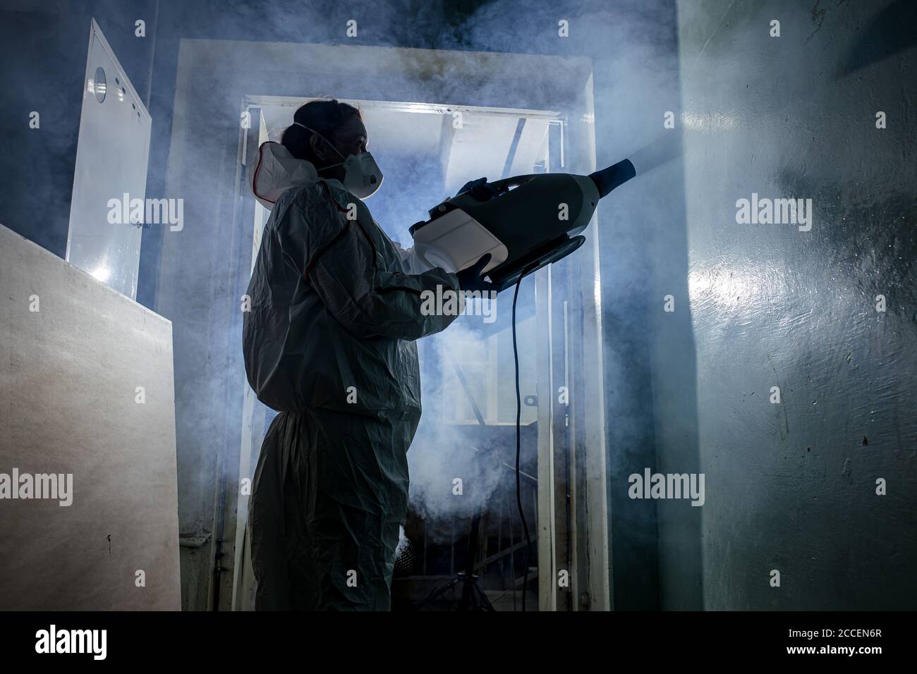 professional disinfector with protective antiviral mask, chemical ...