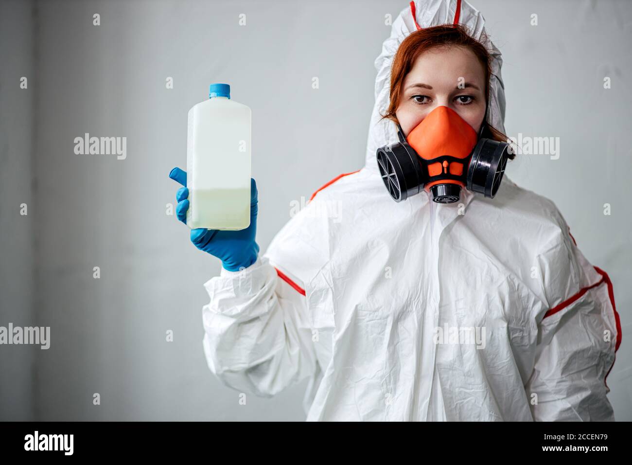 professional female disinfector holding disinfectant fluid in hands ...