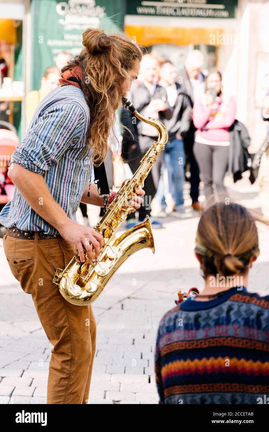 Vertical photo of a saxophone player on his back playing saxophone next ...