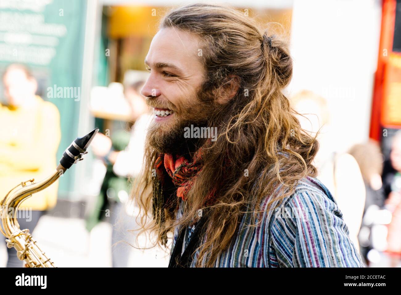 Portrait of the profile of a young man with long hair smiling while ...