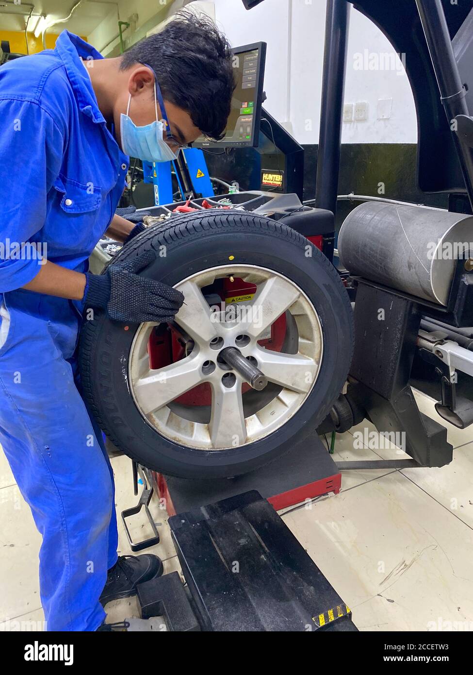 Mechanic balancing wheel with machine balancer at service Stock Photo ...