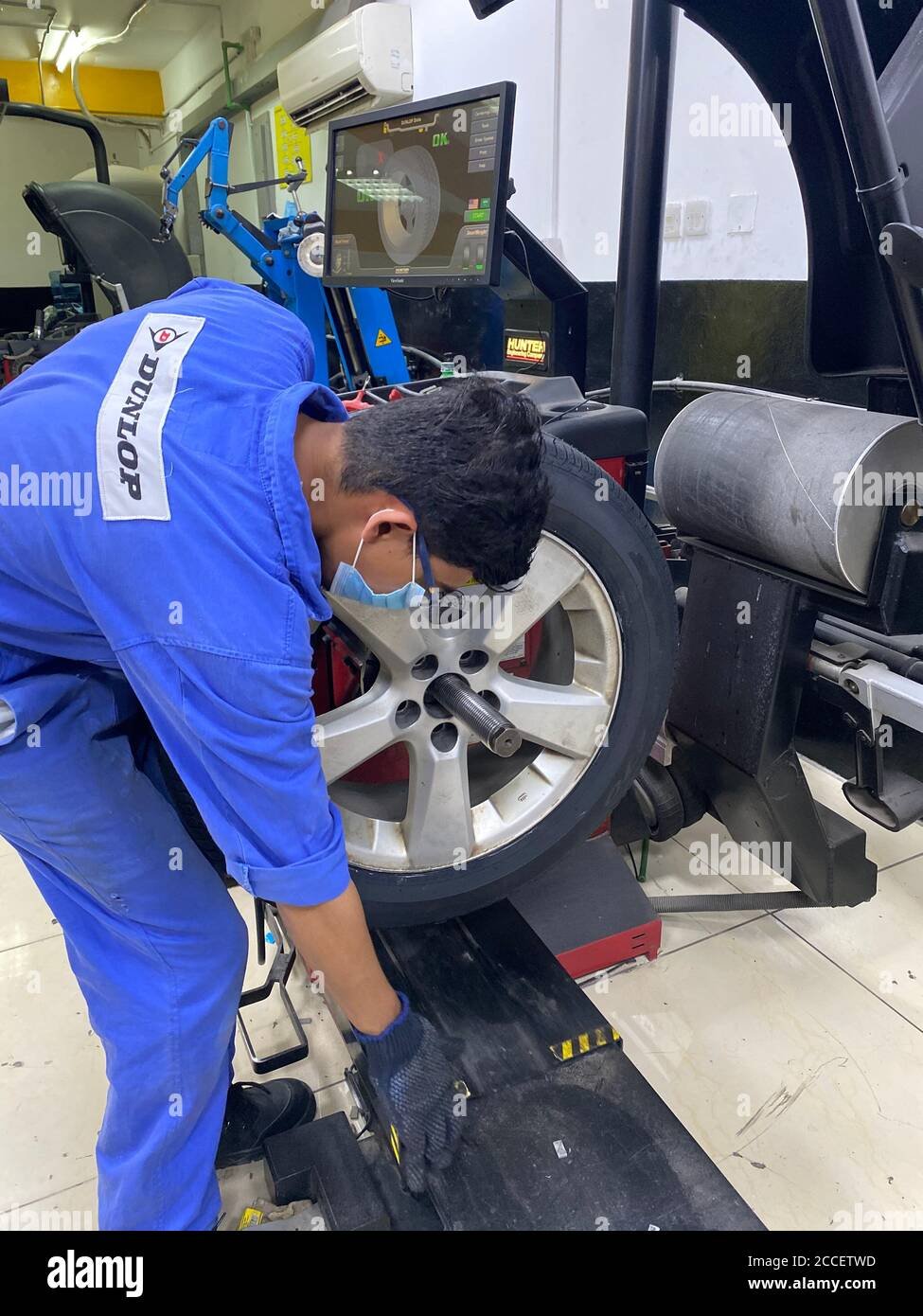 Mechanic balancing wheel with machine balancer at service Stock Photo ...
