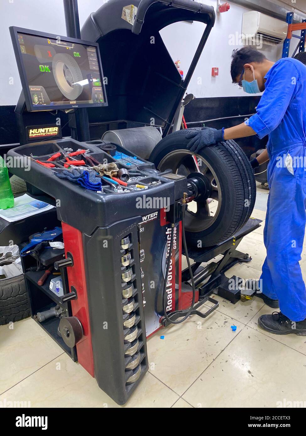 Mechanic balancing wheel with machine balancer at service Stock Photo ...