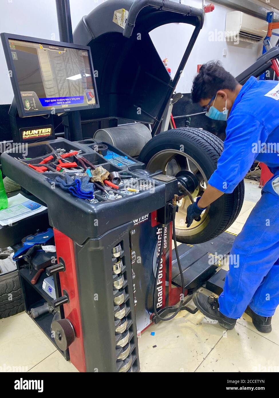 Mechanic balancing wheel with machine balancer at service Stock Photo ...