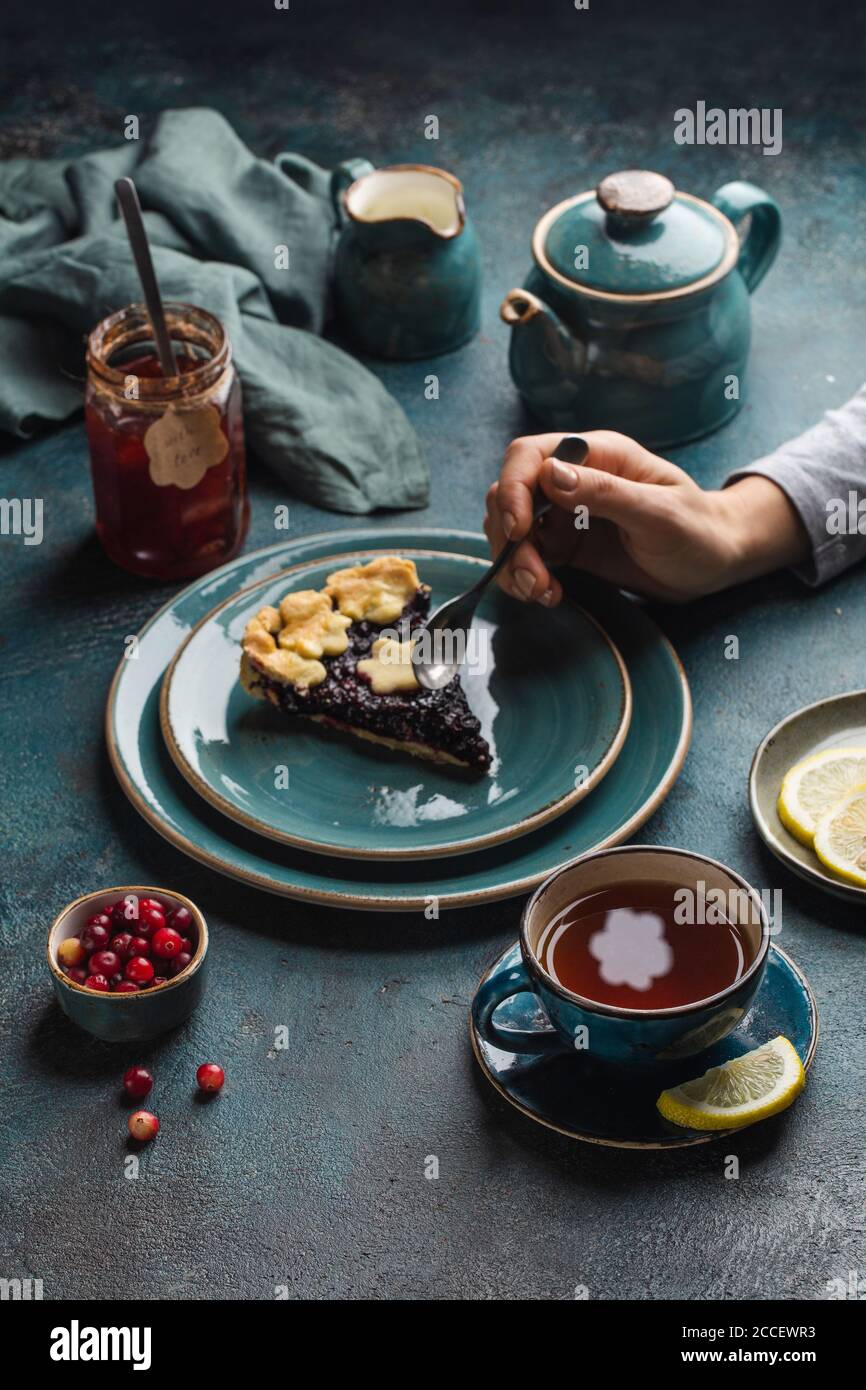 Tea party at the autumn tablewith a slice of berry pie and a cup of hot ...