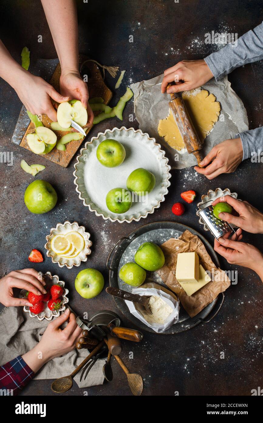 Autumn pies. People are preparing a pie together. Top view in frame ...
