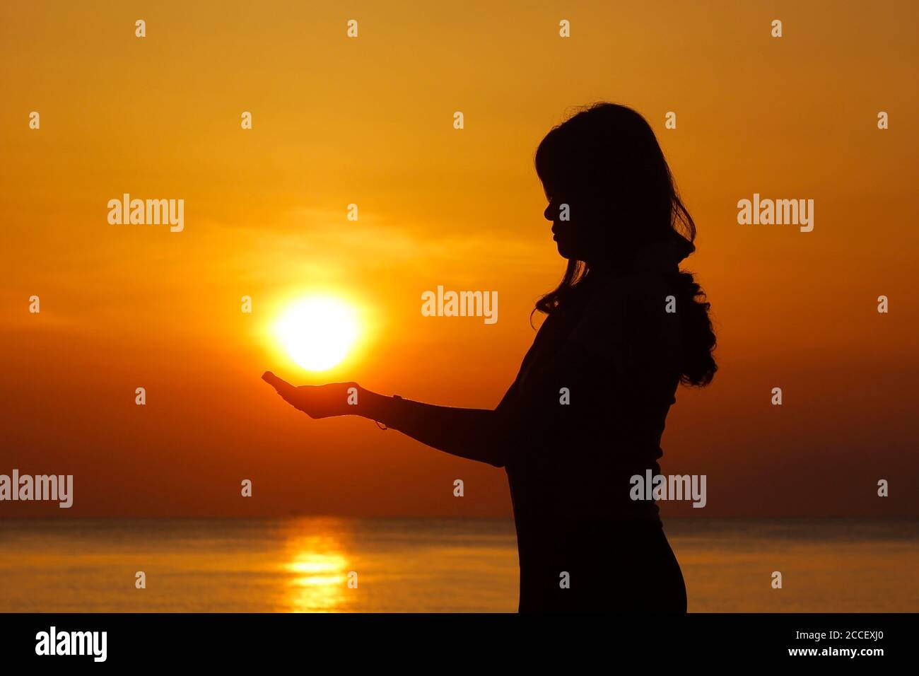 silhouette of female holding sun on the beach Stock Photo - Alamy