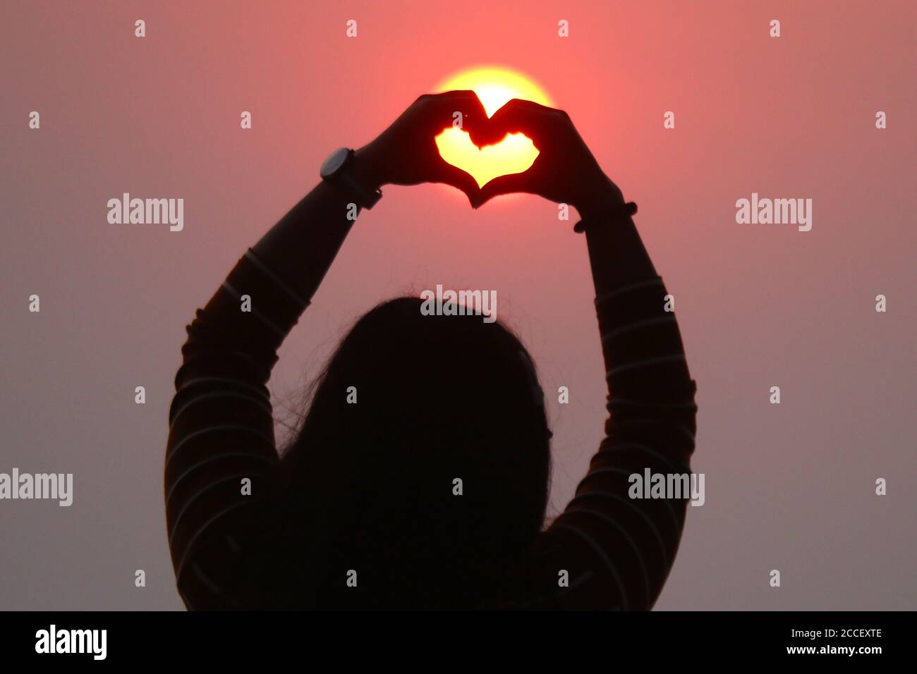 silhouette of female hands make heart shape with sun inside Stock Photo ...