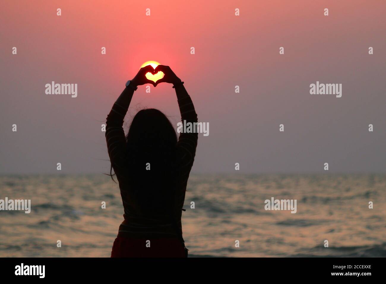 silhouette of female hands make heart shape with sun inside Stock Photo ...