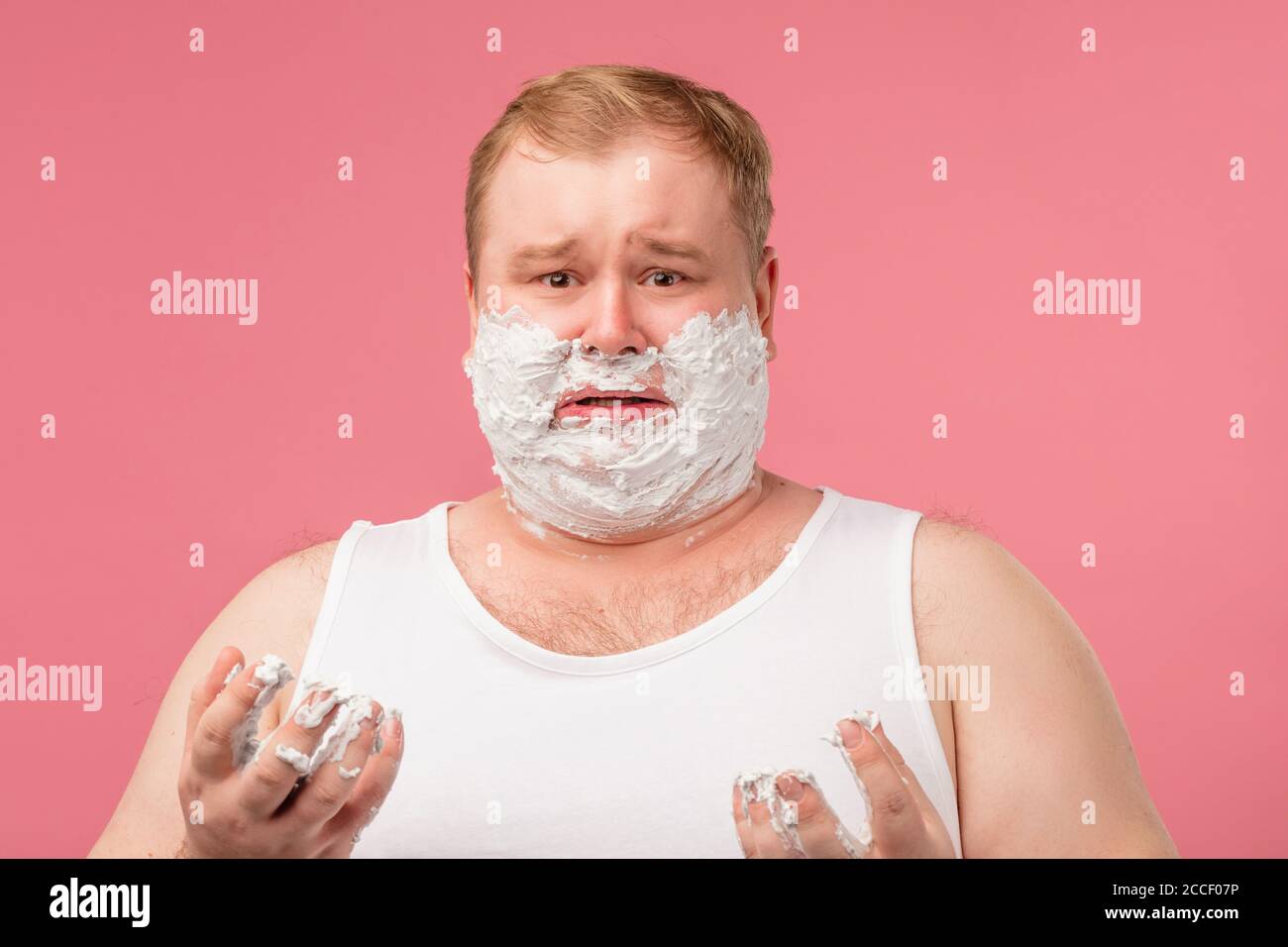 Discontent man with gel foam on cheeks, has sad expression, tired of ...