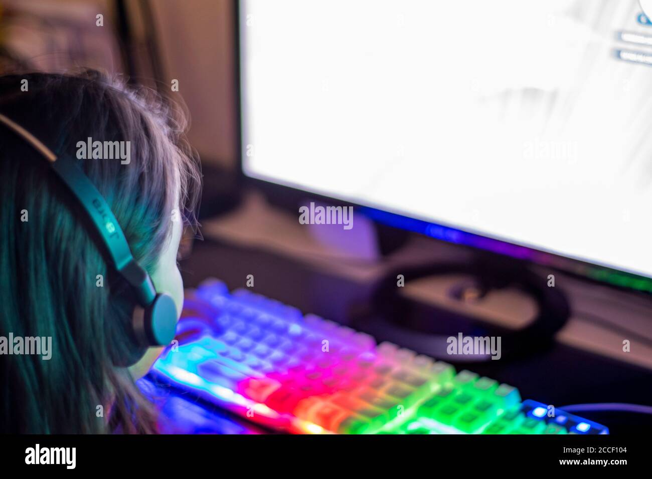 Gaming generation girls with headset and colorful keyboard looking at ...