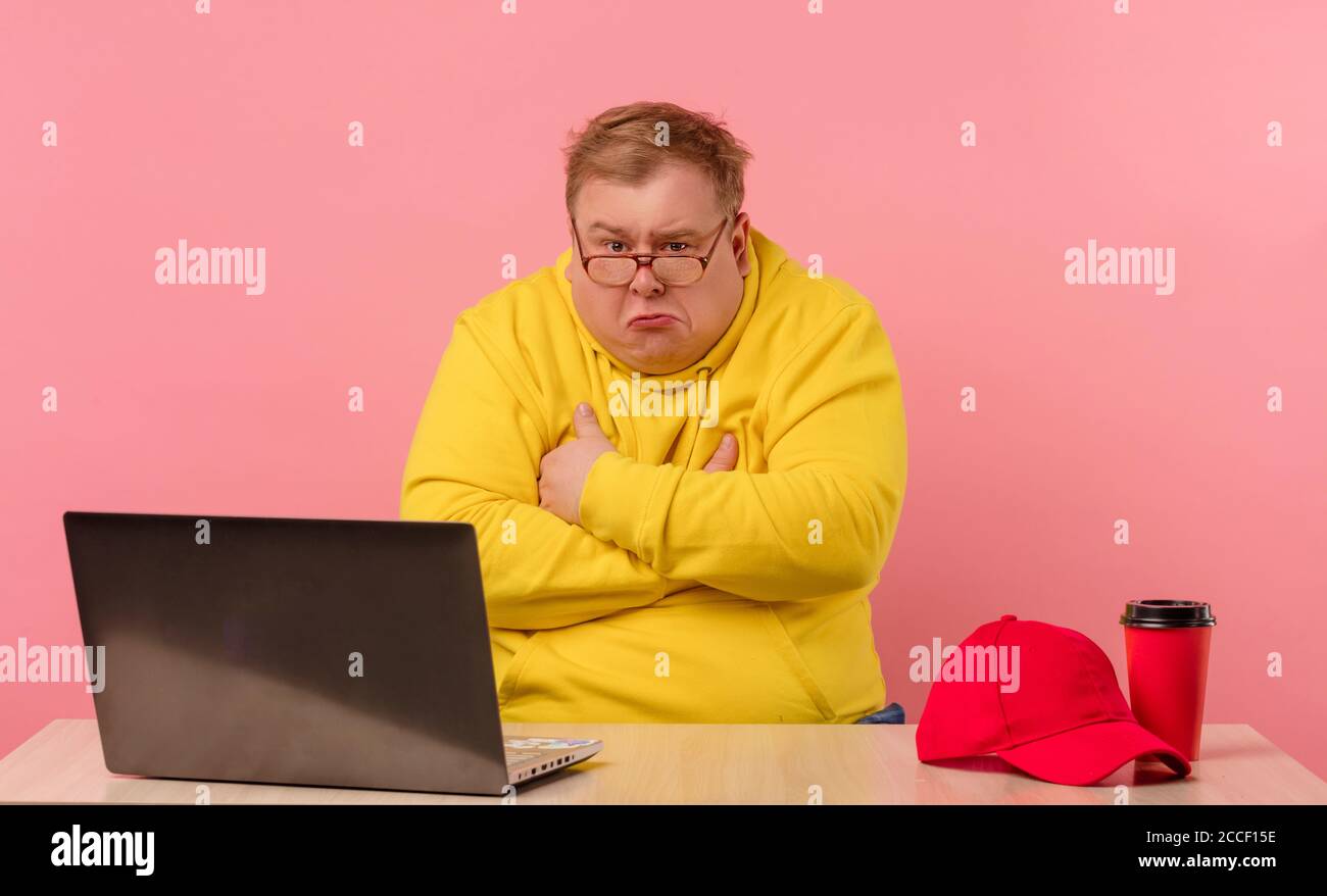 Puzzled displeased man in yellow sweatshirt looking at camera while ...