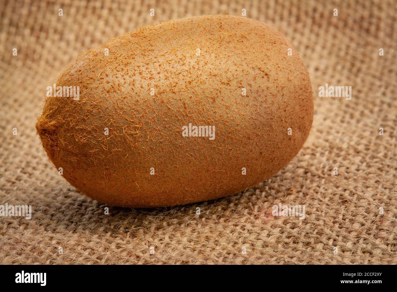 Single Kiwi Fruits On Sackcloth Stock Photo - Alamy