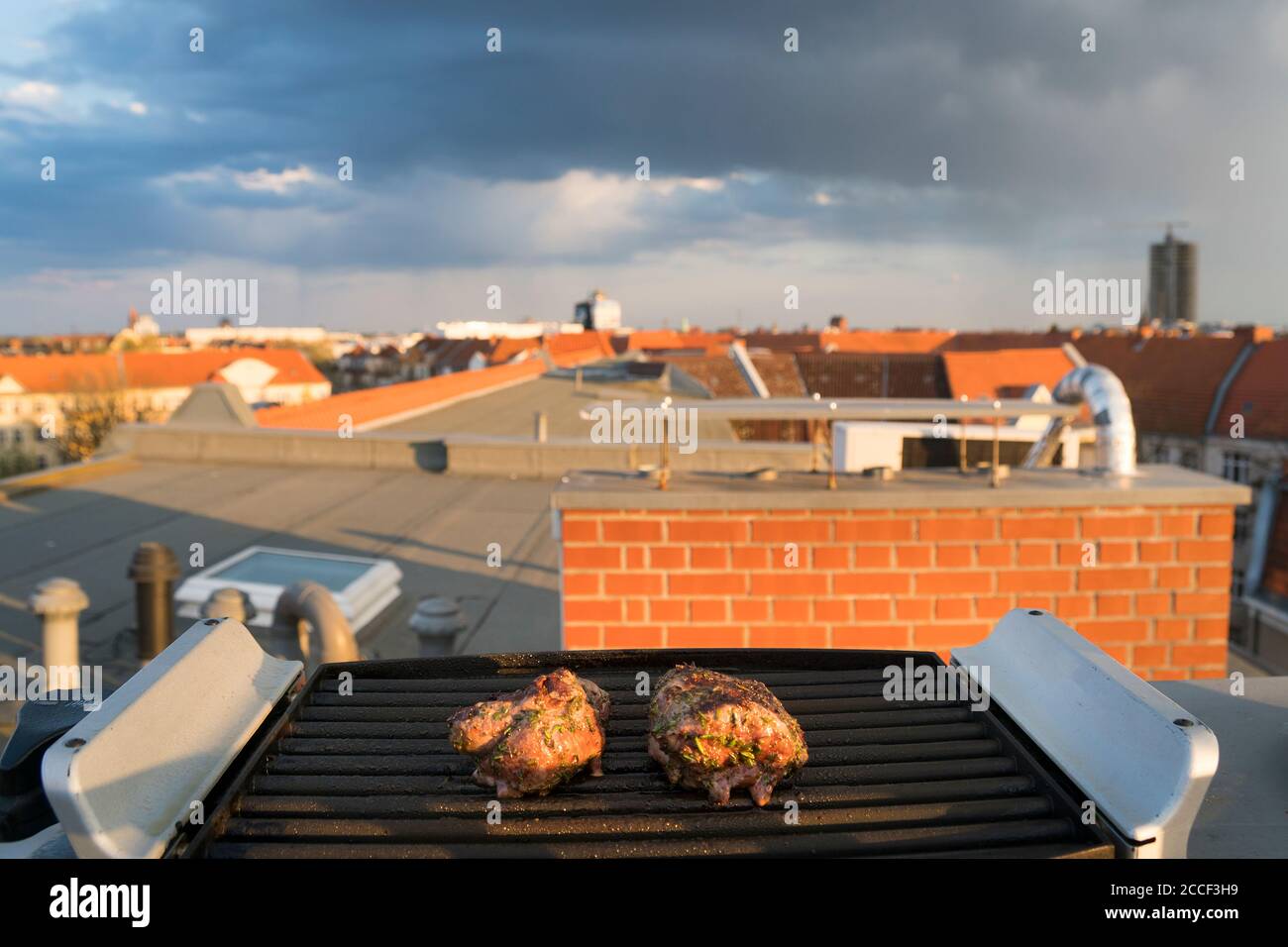 Berlin, attic, terrace, grill with lamb Stock Photo - Alamy