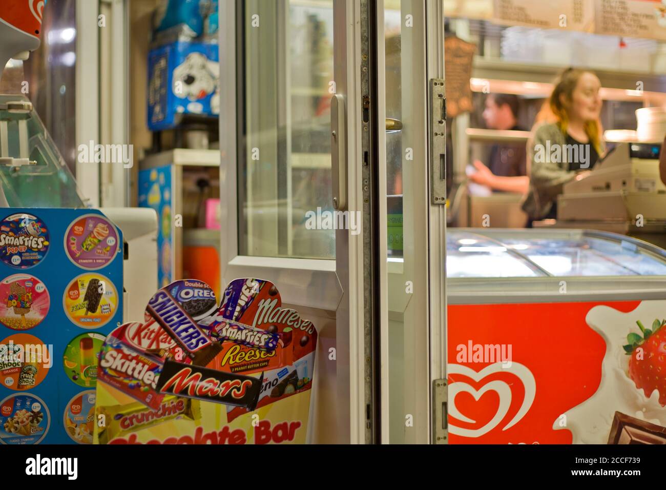Items for sale at an ice cream shop, with a server in the background ...