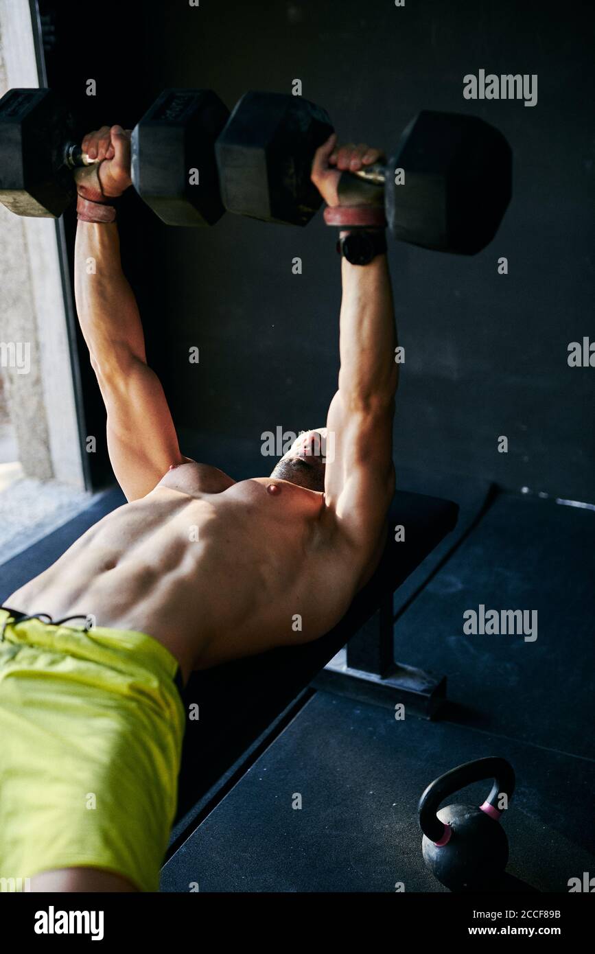 Shirtless fit young man working out in a garage with dumbells Stock ...