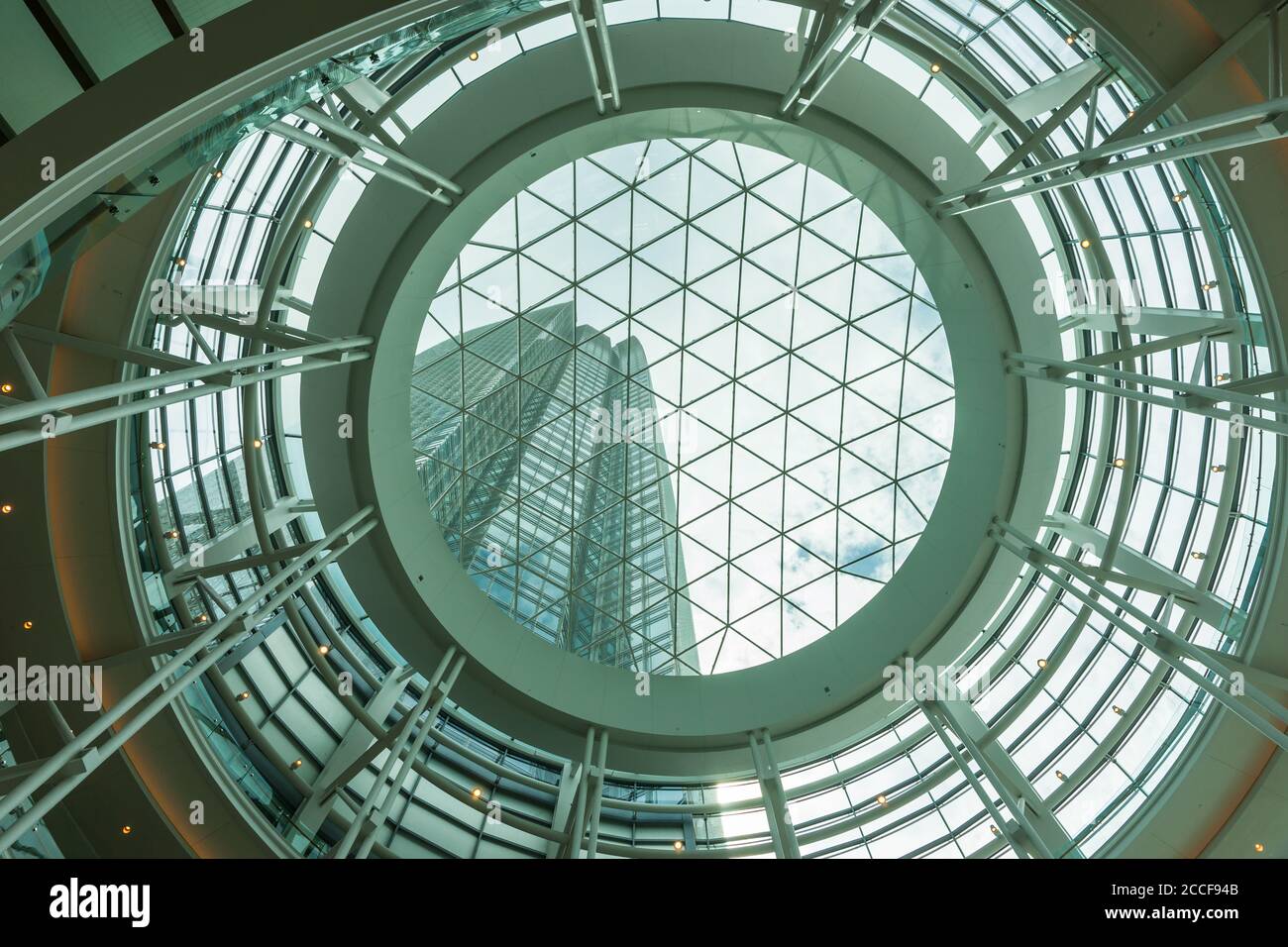 View through glass and steel circular dome to high-rise office building ...