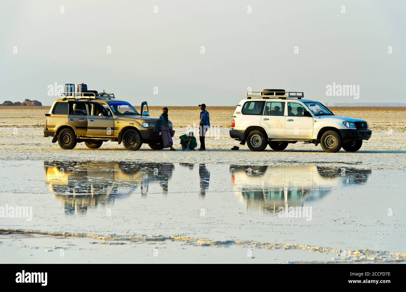 Two four-wheel drive vehicles with attendant staff stand in front of a ...